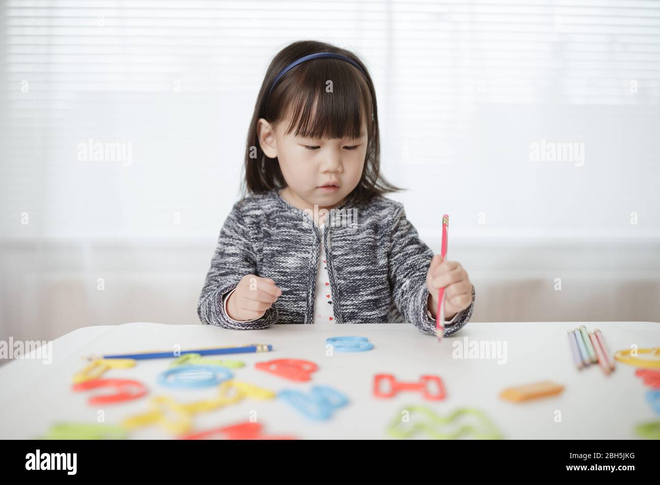 toddler girl practice writing letters for homeschooling Stock Photo - Alamy