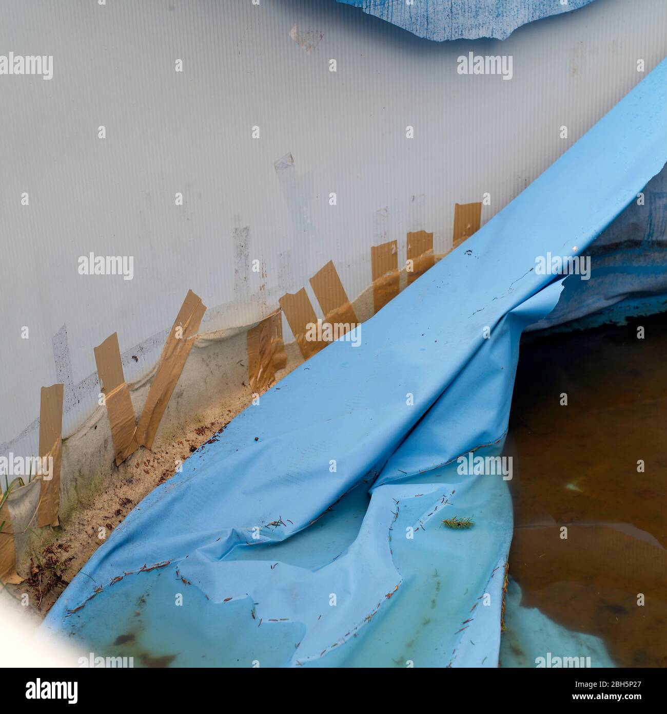 Outdoor damaged pool with dirty water repair with sticky tape Stock ...