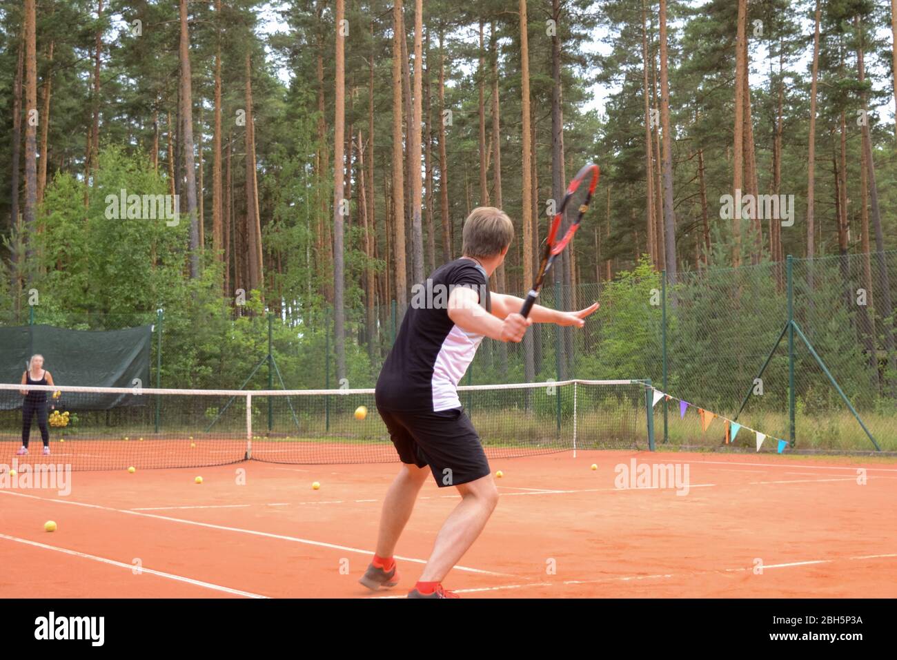 back view of a male tennis player with a racket waiting for a pass from ...