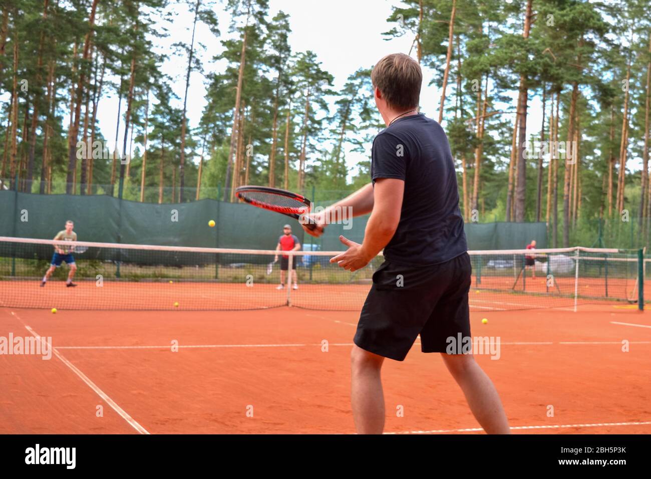 back view of a male tennis player with a racket in action Stock Photo ...