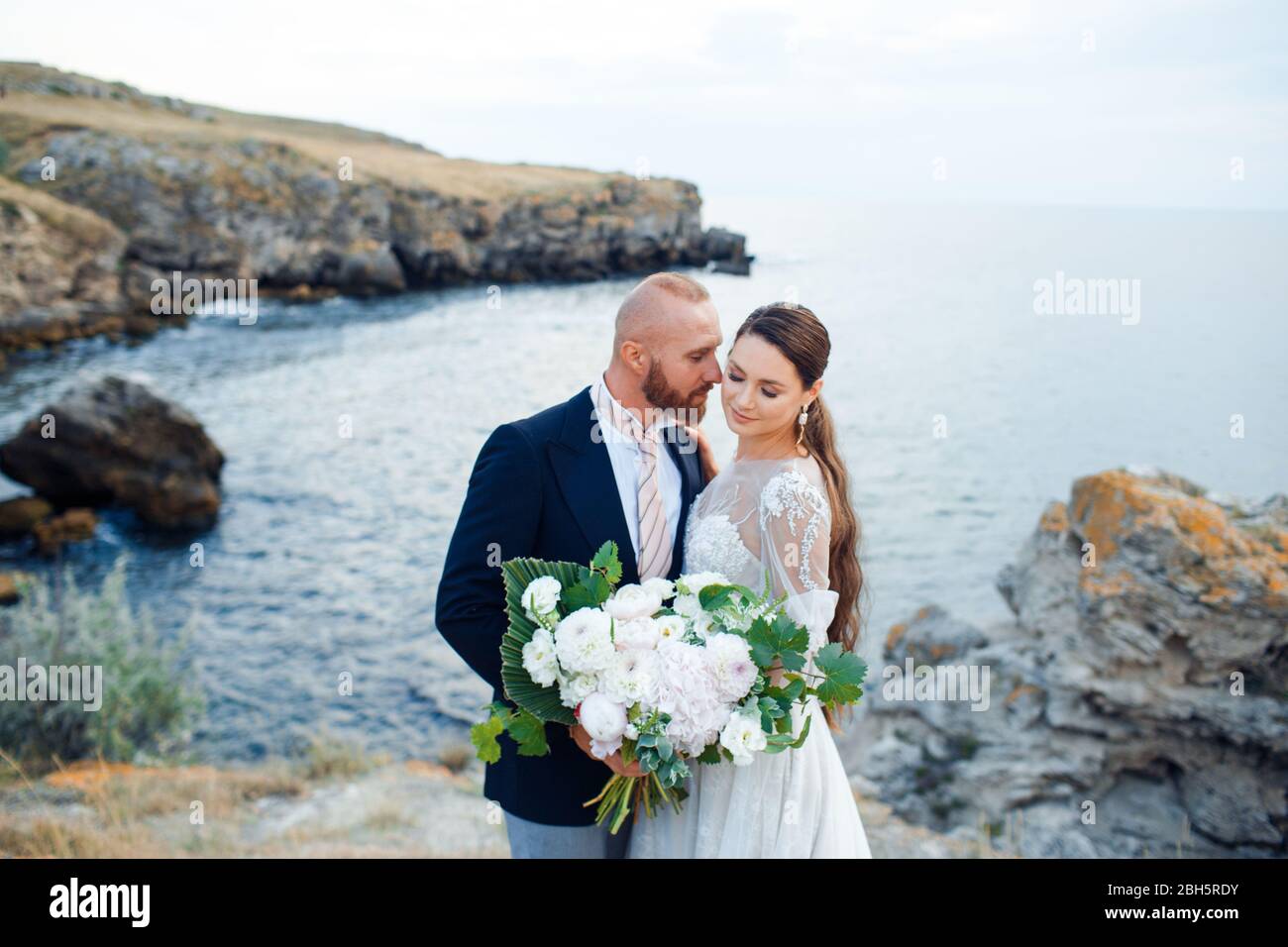 Wedding couple by the sea in boho style Stock Photo - Alamy