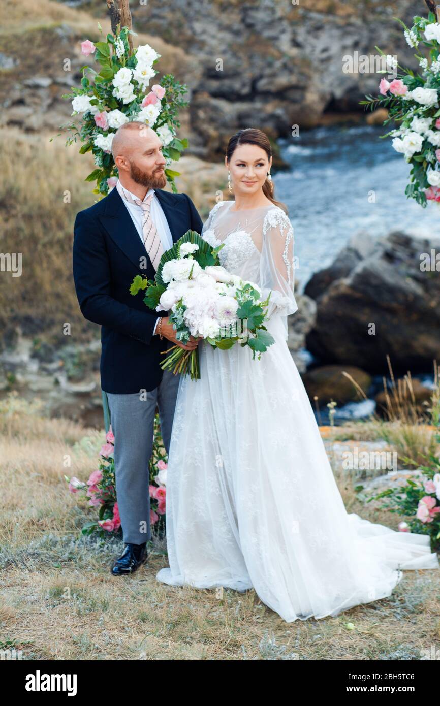 Wedding couple by the sea in boho style Stock Photo - Alamy
