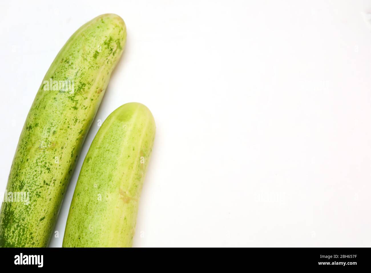 Two cucumbers on an isolated white background Stock Photo - Alamy