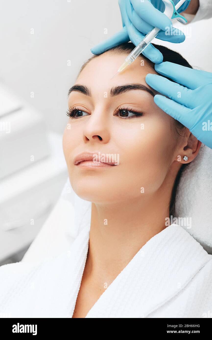 doctor injects doing injection to lift the face of a beautiful woman to ...