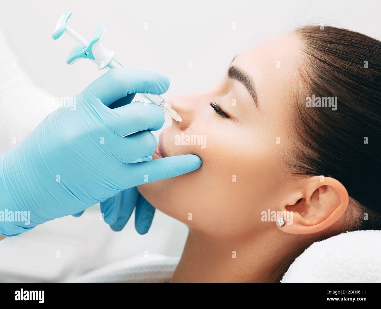 doctor injects doing injection to lift the face of a beautiful woman to ...