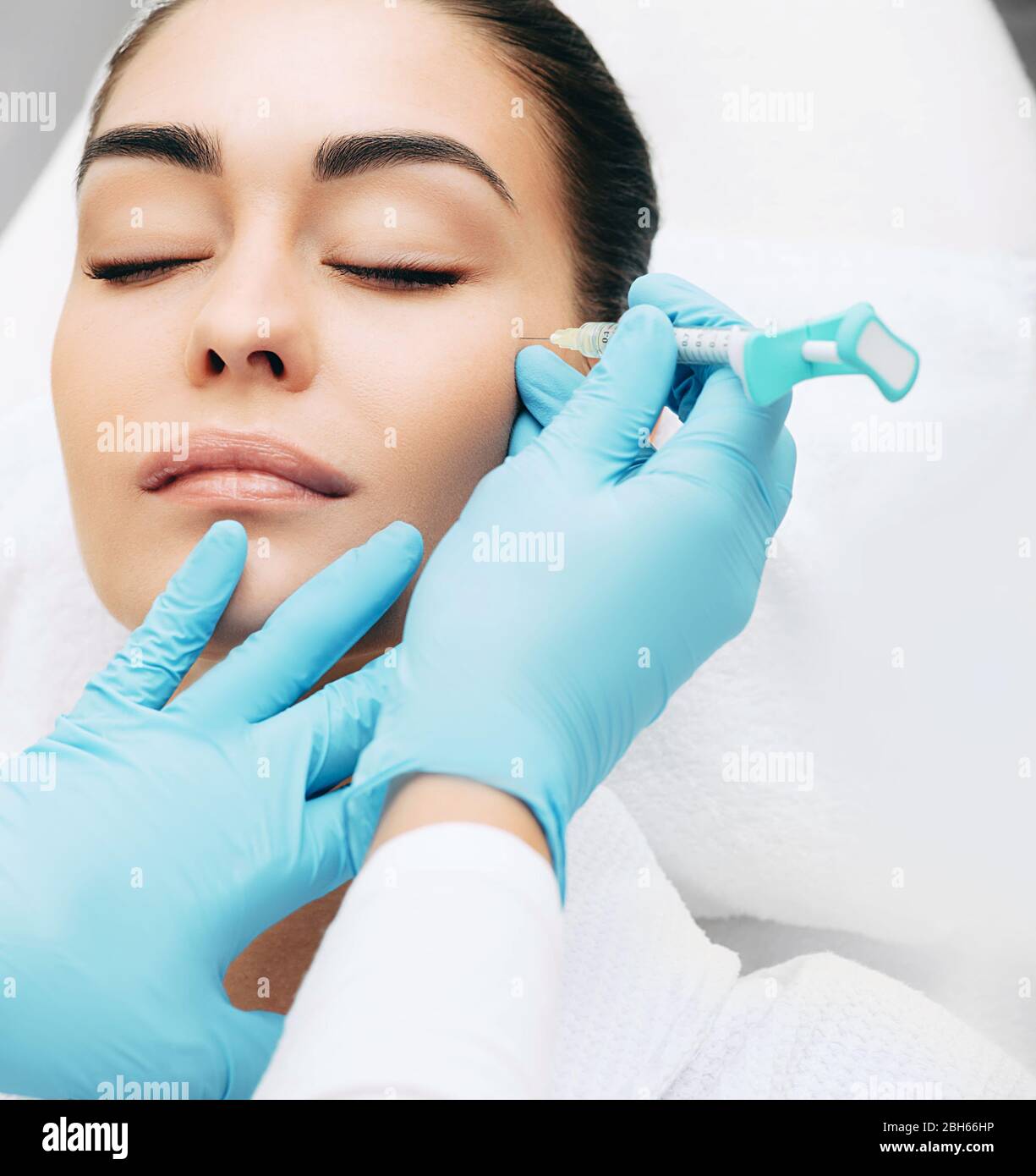 doctor injects doing injection to lift the face of a beautiful woman to ...
