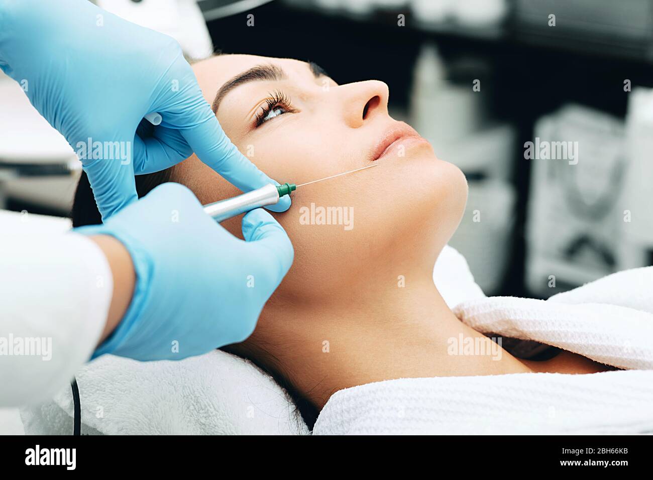 woman having facial injections for facelift and anti-aging effect. Lip ...