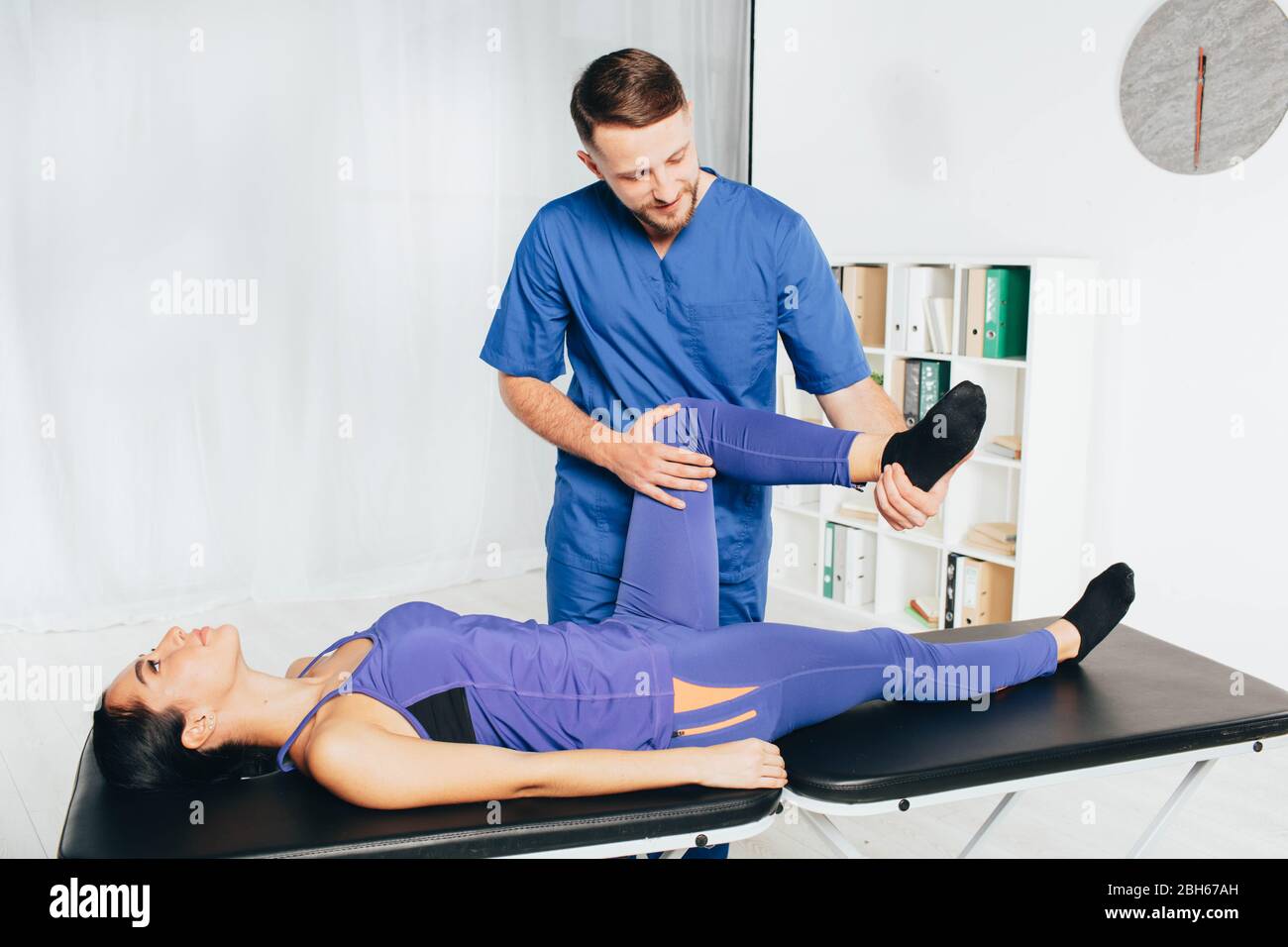 woman visiting her physiotherapist. patient doing exercise for ...