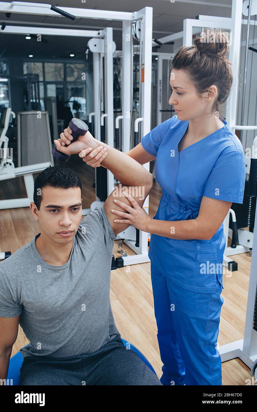 Physiotherapist training with mixed race patient. Physiotherapy ...