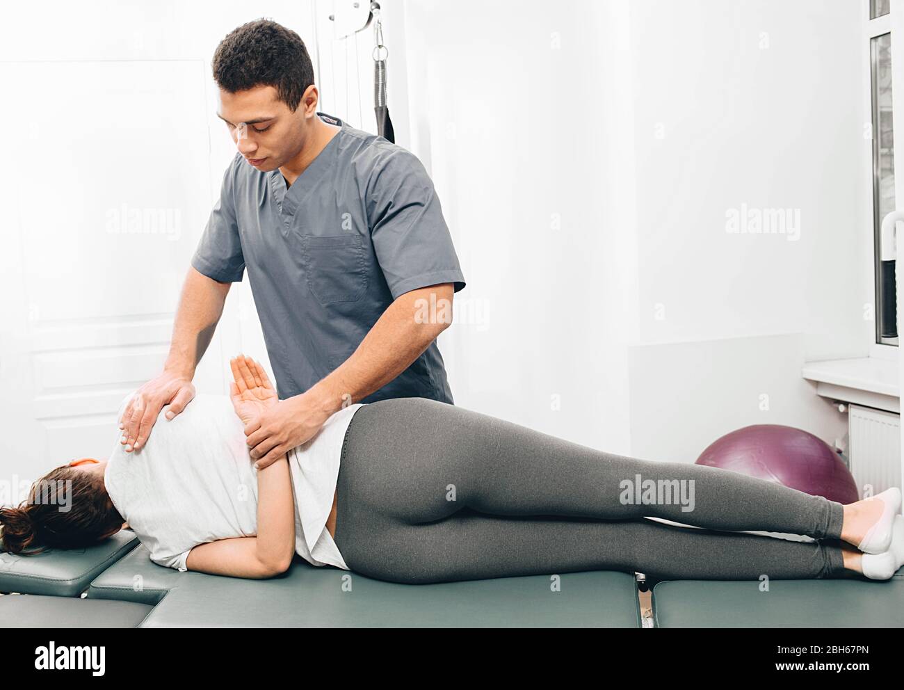 Physiotherapist treatment patient. His holding patient's hand, shoulder ...