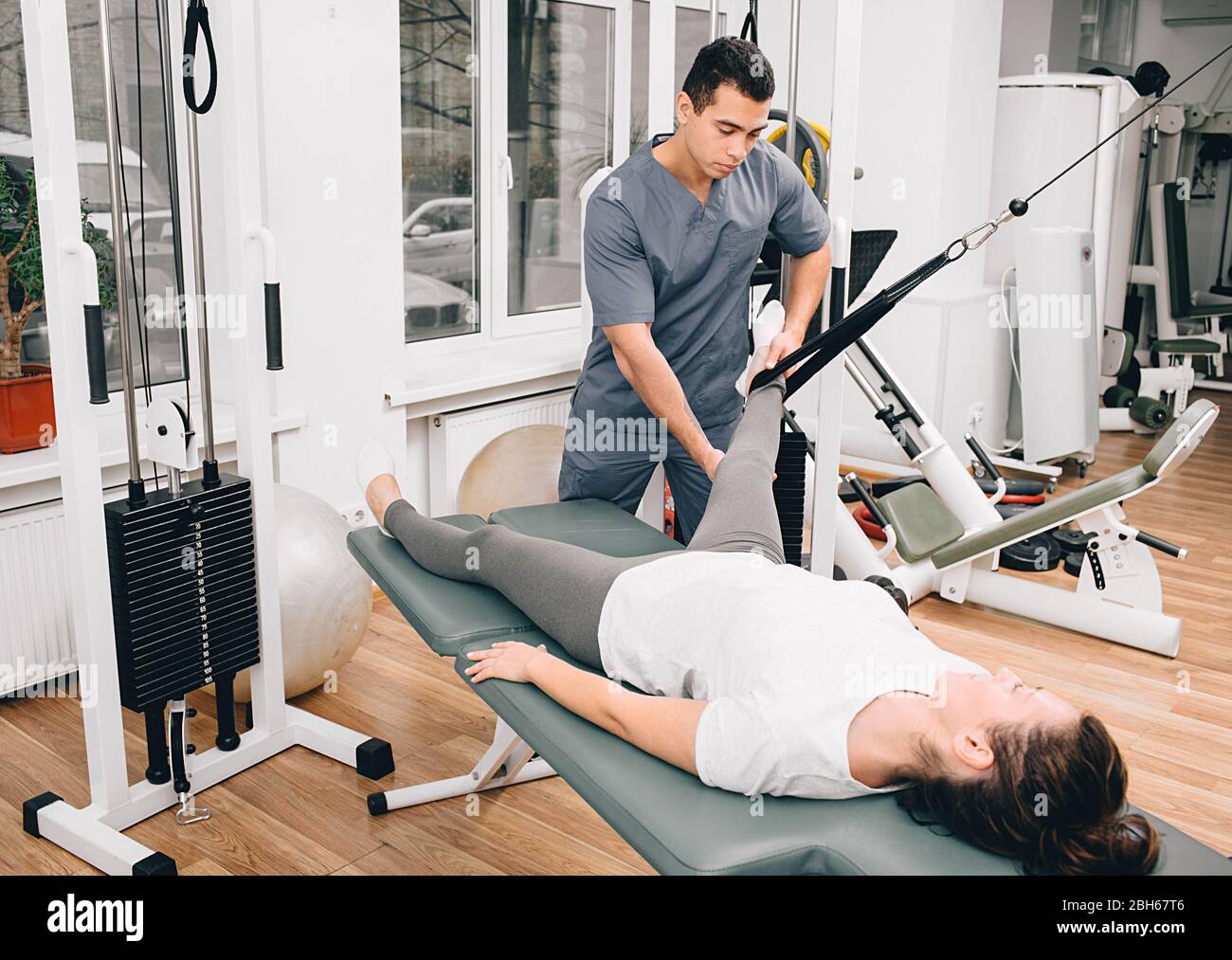 kinesiologist doing therapeutic exercises to restore the hip joint for ...
