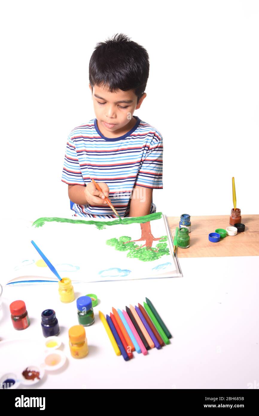 High Key image of Little kid drawing and painting on the paper in room ...