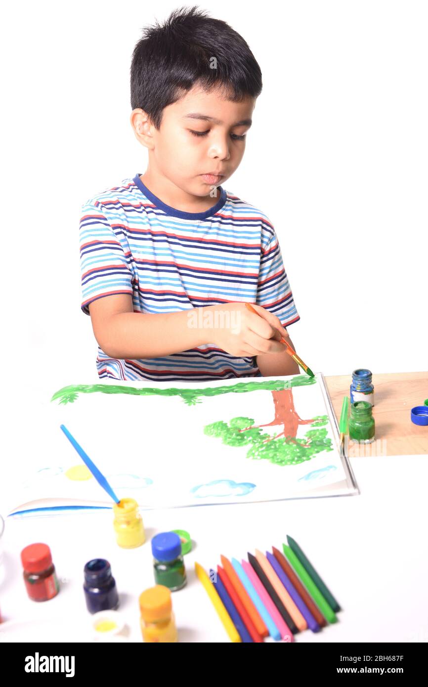 High Key image of Little kid drawing and painting on the paper in room ...