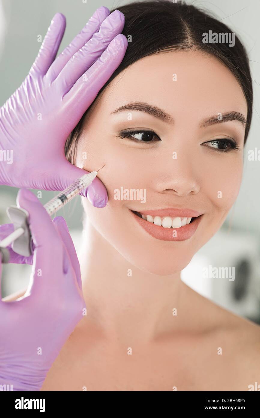 Beautiful Asian woman gets beauty injections. Close-up injection of ...