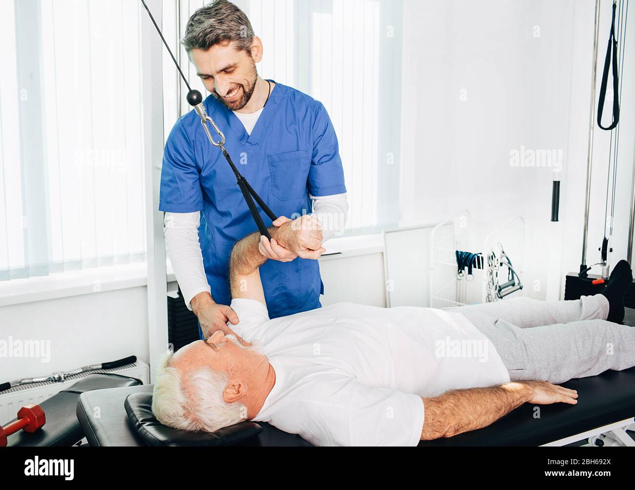 kinesiologist doing therapeutic exercises for an elderly patient ...