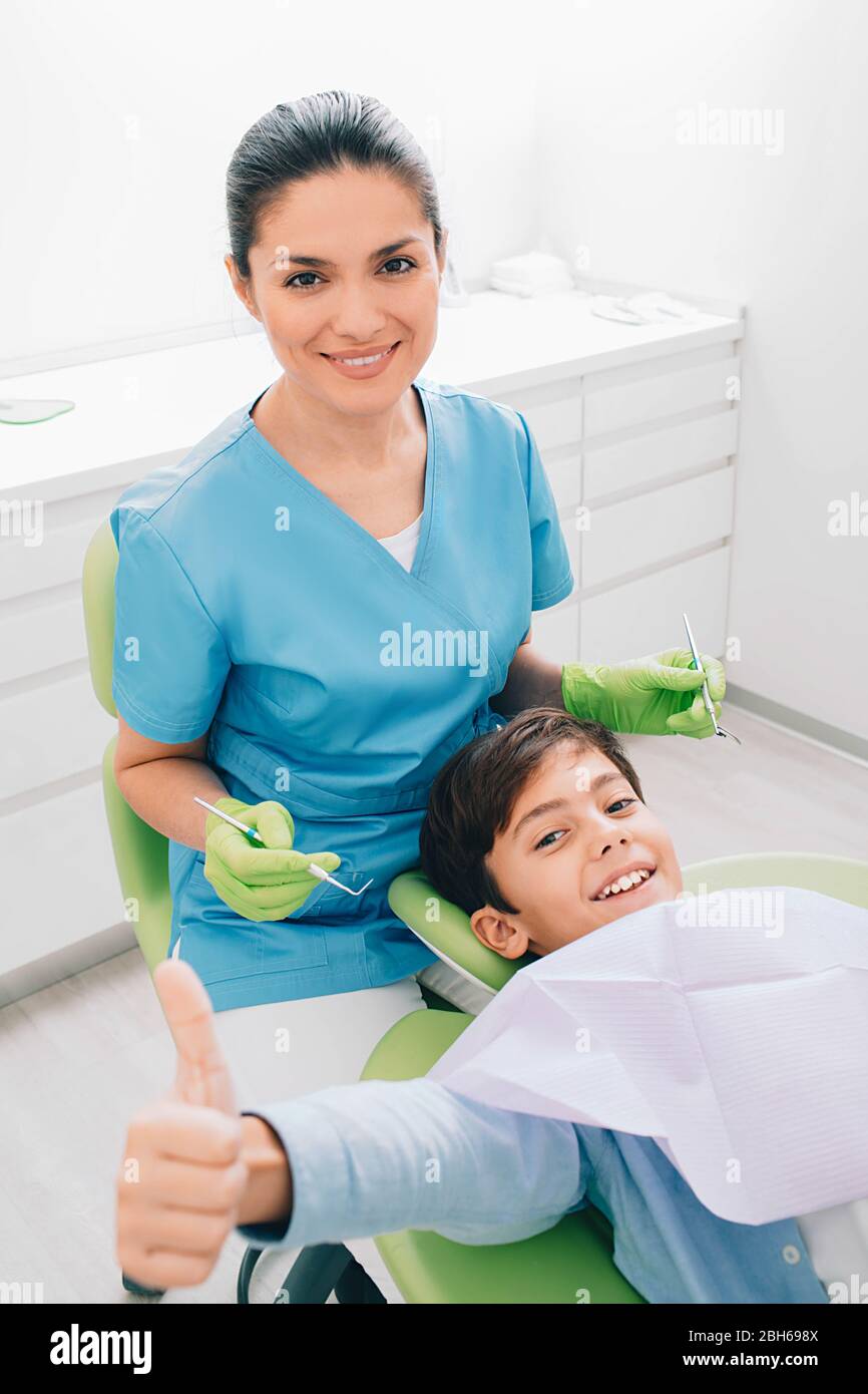 Happy little boy showing thumbs up. He visiting pediatrician dentist ...