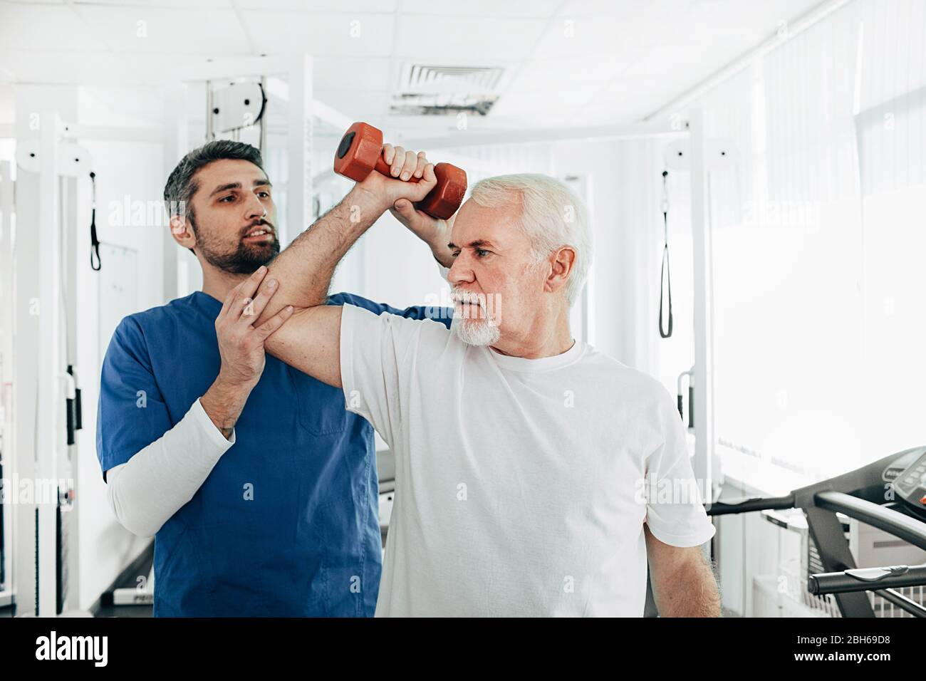 senior man lift a dumbbell, he doing treatment exercise with his ...