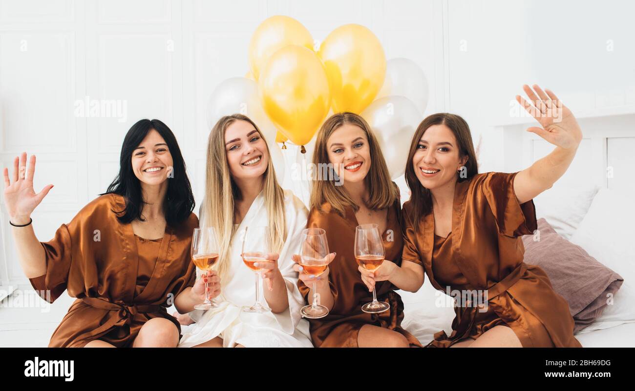 hen party. Beautiful charming women wearing in satin robe drinking ...