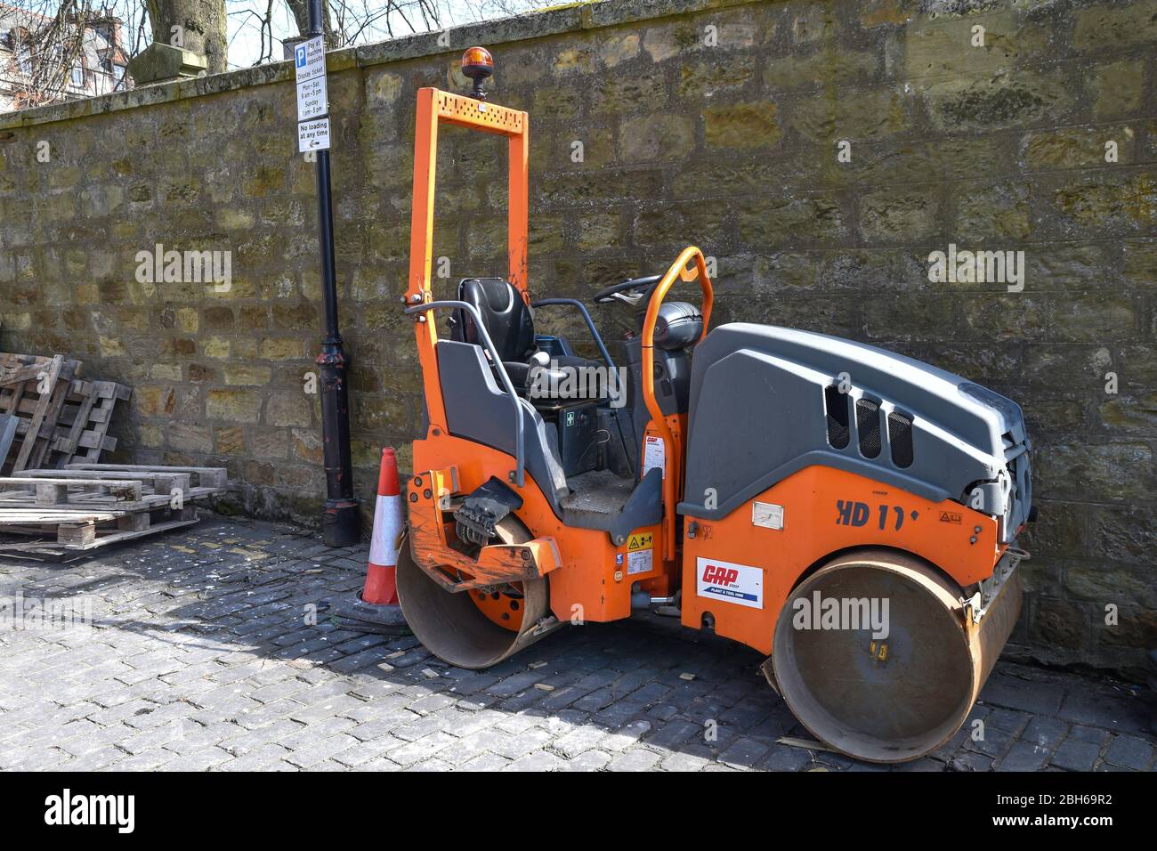 Orange steamroller on cobbled street Stock Photo - Alamy
