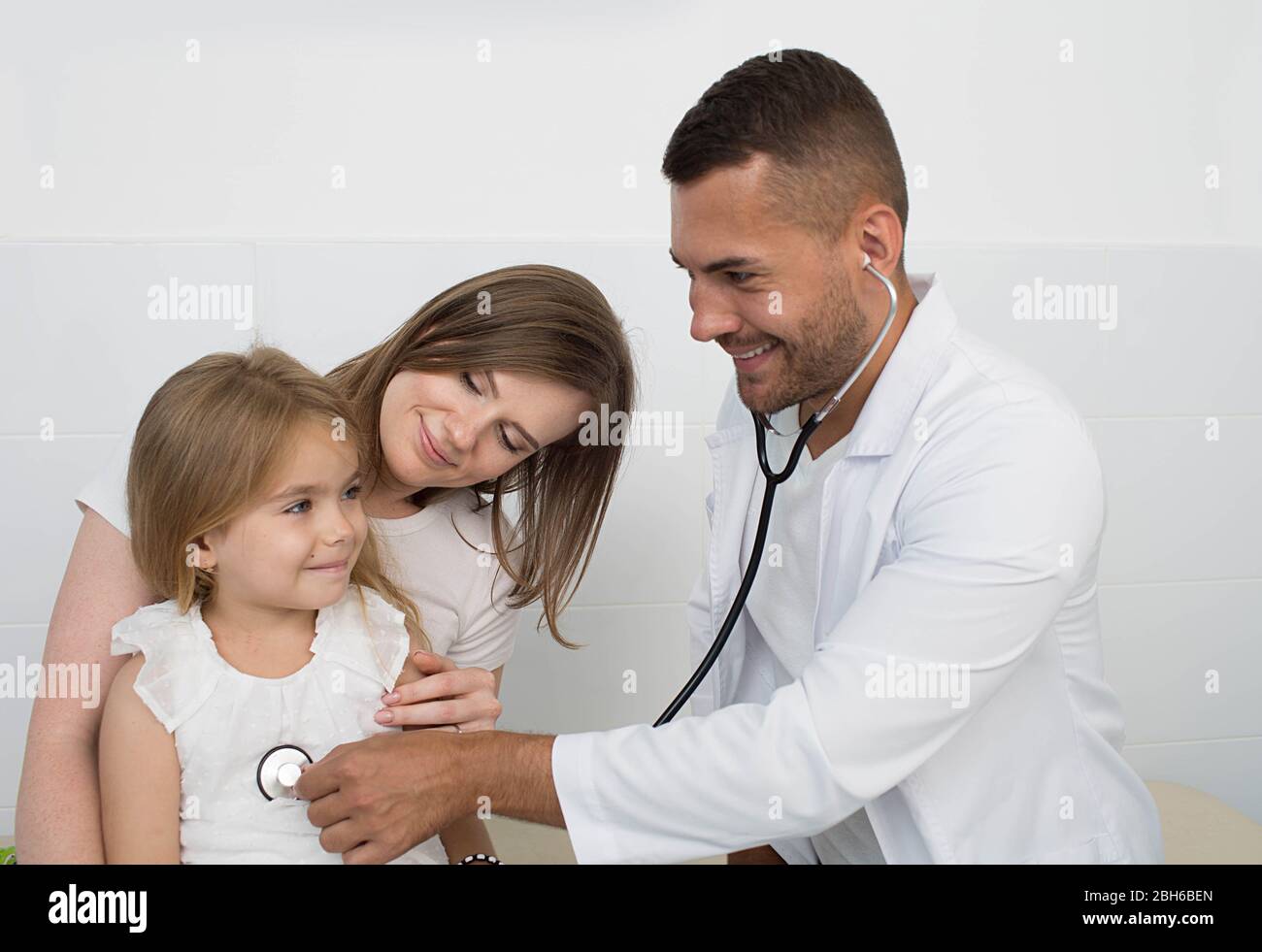 Positive pediatric doctor while working with a child. mother with a ...