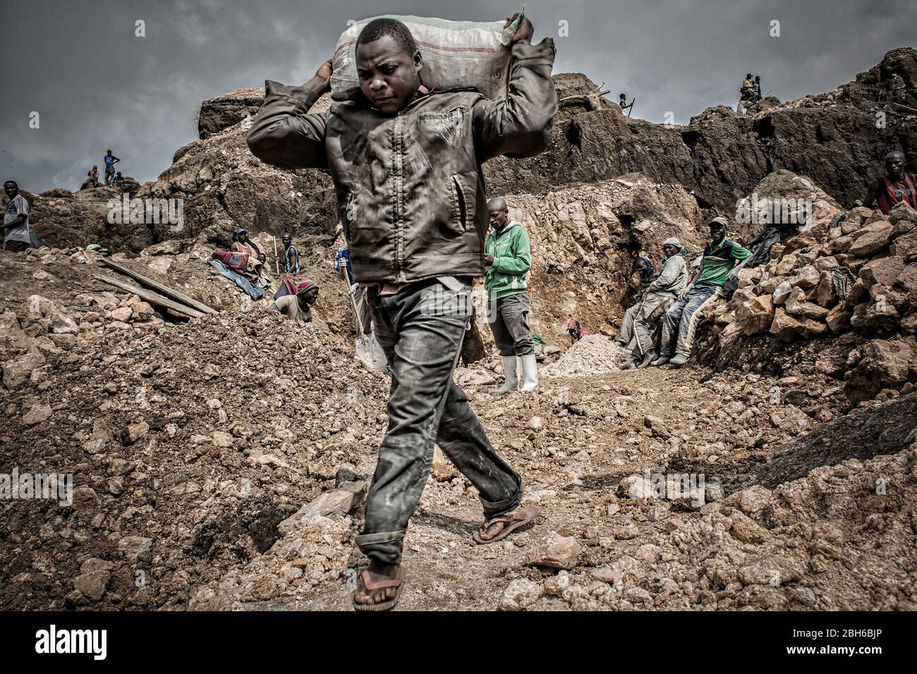 Coltan illegal mining in Democratic Republic of Congo. Miners carrying minerals at Rubaya town ...