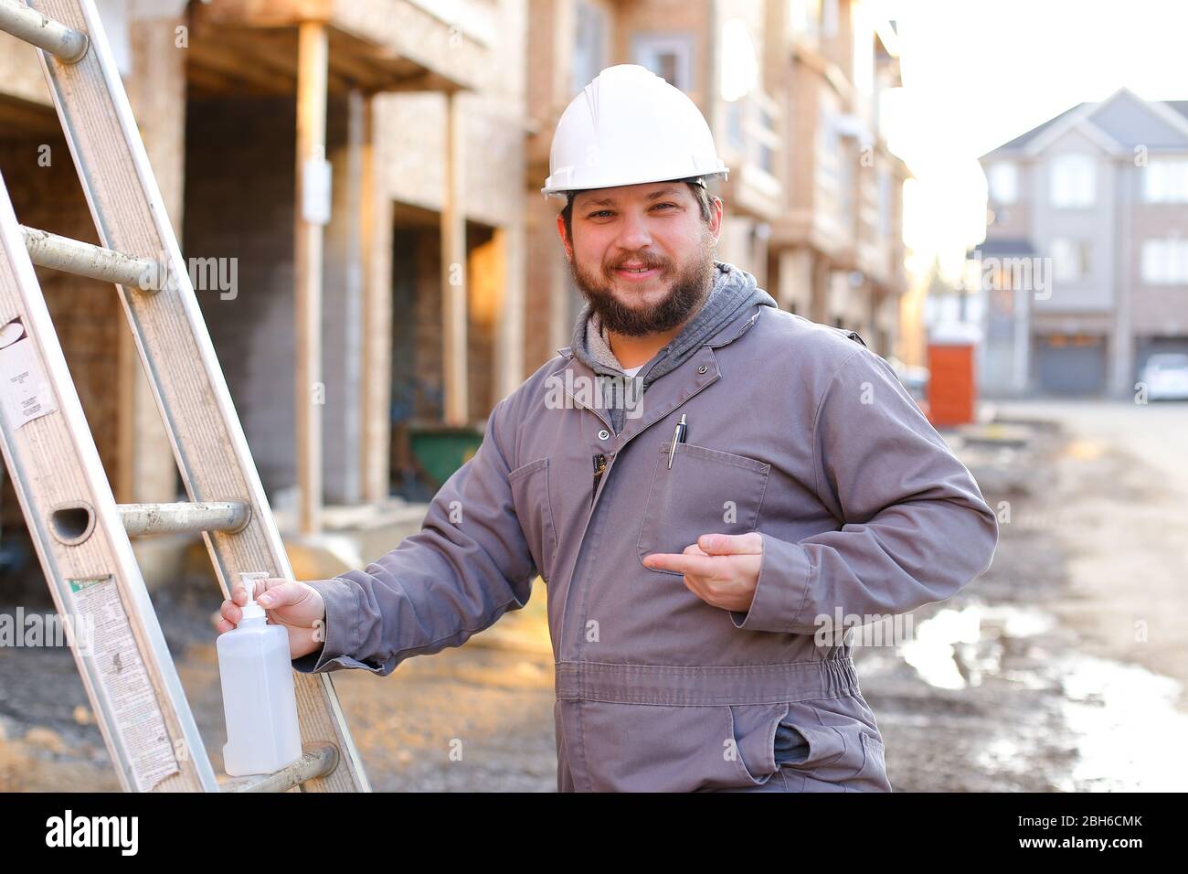 Young foreman using disinfectant soap on construction site Stock Photo ...