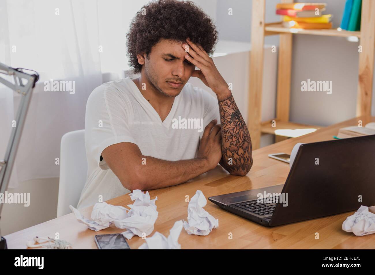 Hard work day. Attractive man designer, Feeling tired, leaning his head ...