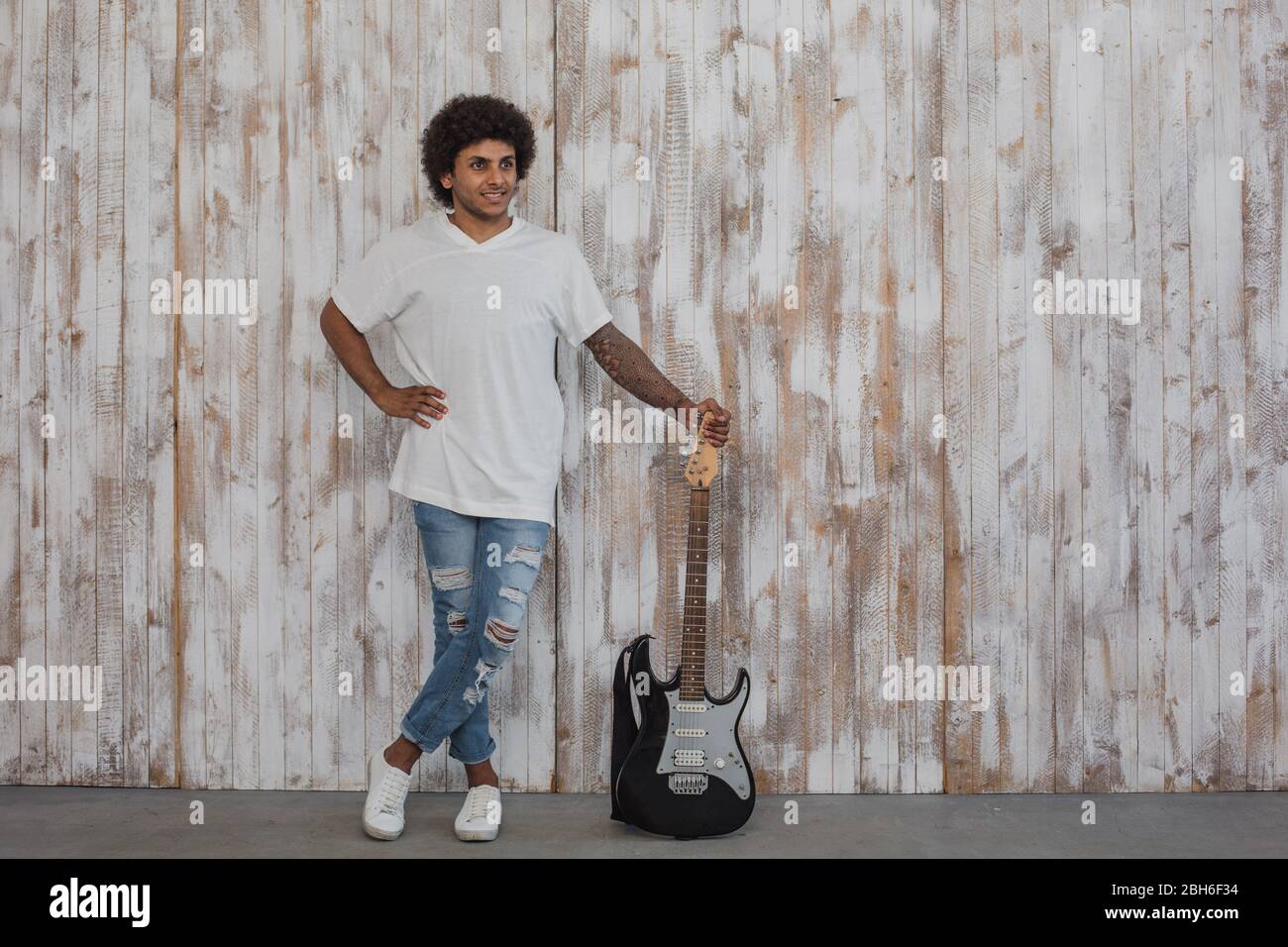 Creative person. Mulatto man musician, with curly hair stands near the ...
