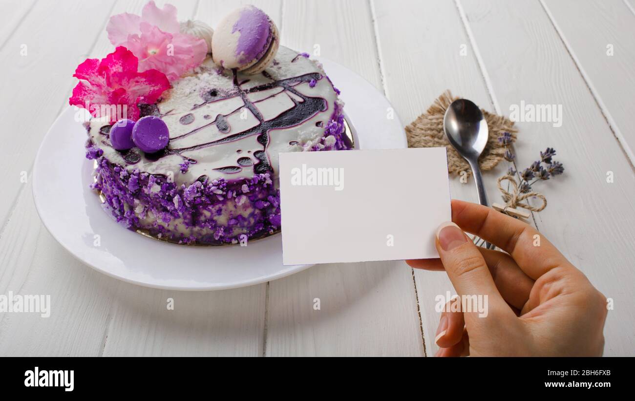 close-up, female hand holding empty blank on background cake with a ...