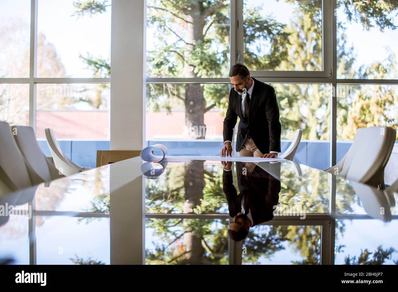 Handsome architect checking plans and blueprints in the office Stock ...