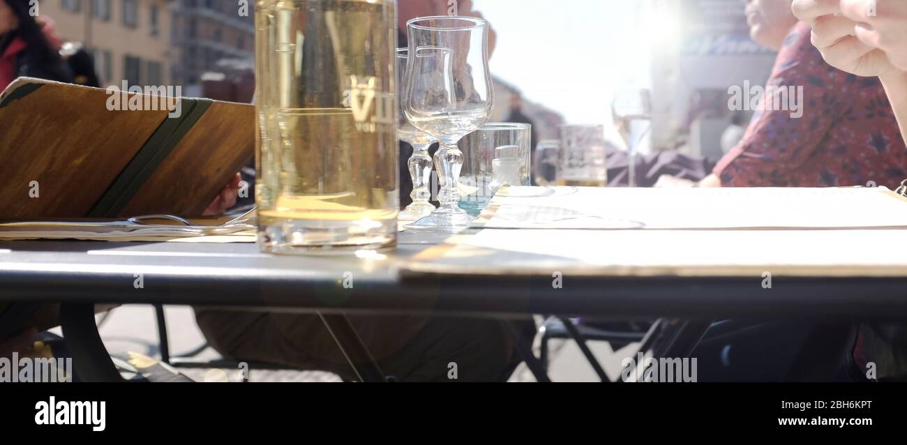 Perspective view of tables in outdoor restaurant. People waiting for ...