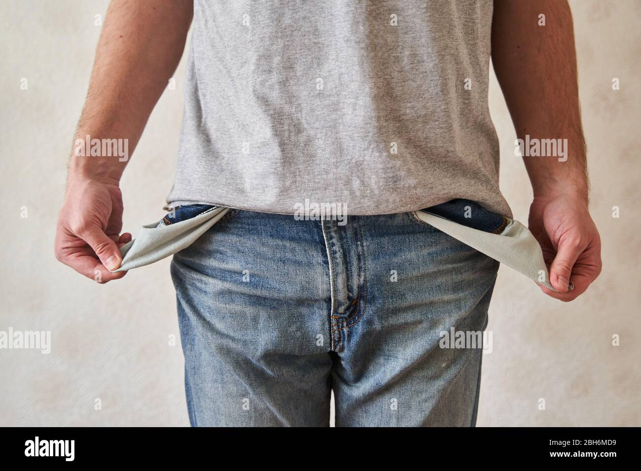 Inverted empty pockets. The young man turned out empty jeans pockets ...