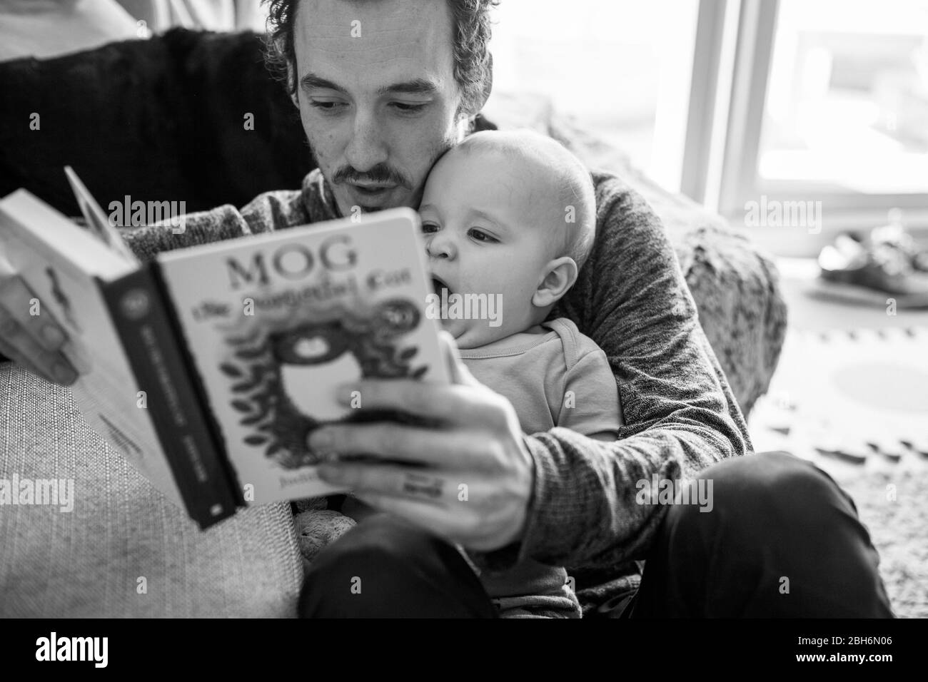 Father reading book to baby son Stock Photo - Alamy