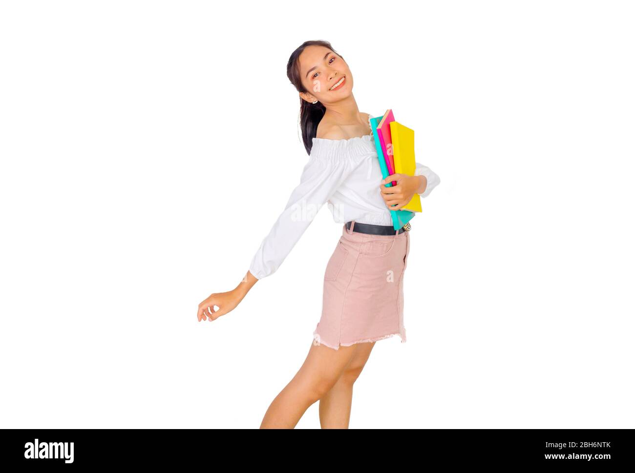 A girl holds three books at her chest Stock Photo - Alamy