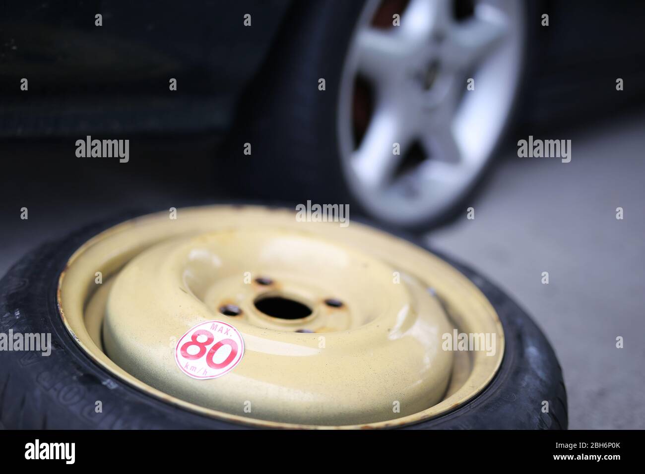 Flat tyre on road. Car tire leak because of nail pounding. Wheel damage ...