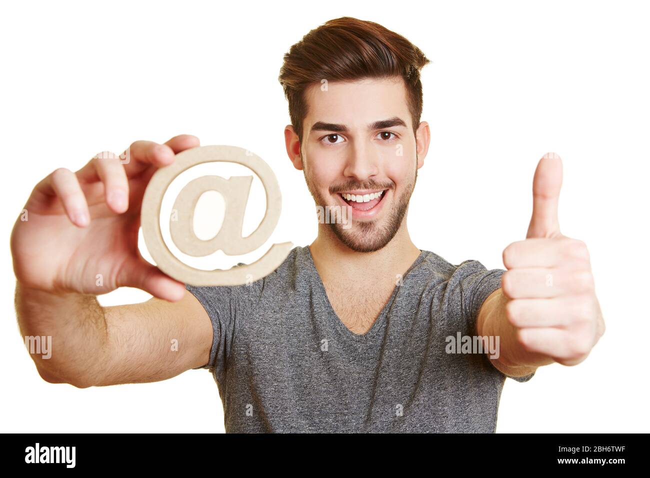 Young laughing man with an at sign holds the thumb up Stock Photo - Alamy