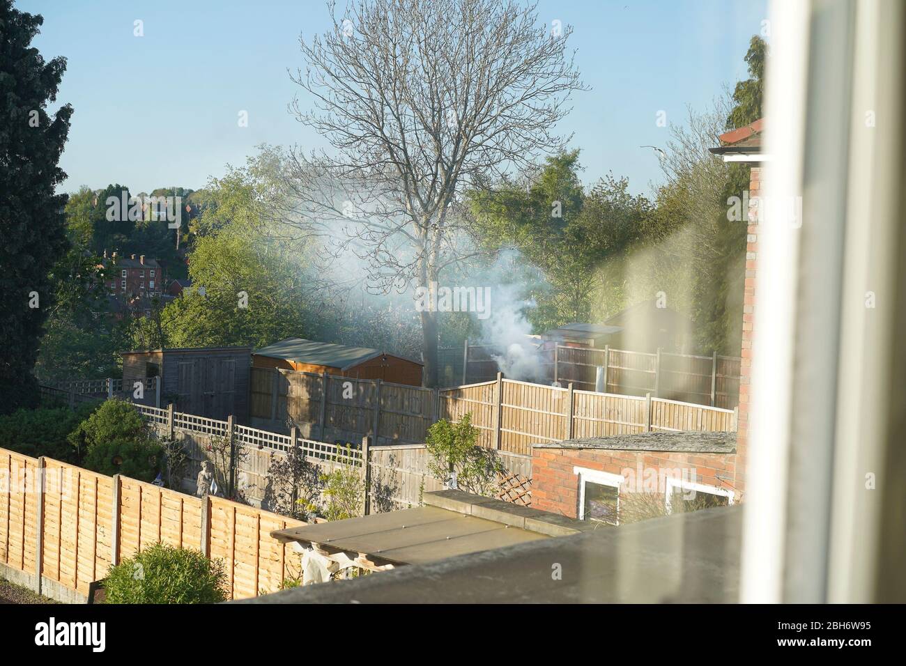 View through window of urban smoke pollution from garden bonfire ...