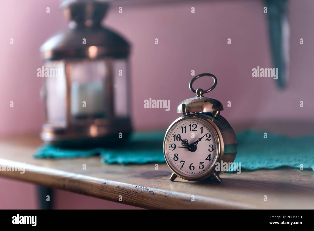 Vintage alarm clock on a shelf lit by morning sun rays. Vintage ...