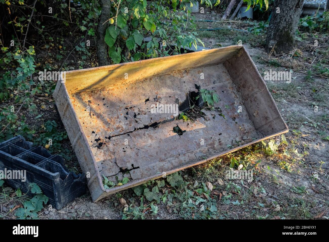 Old rusty holey steel trough. Scrap metal is rusty Stock Photo - Alamy