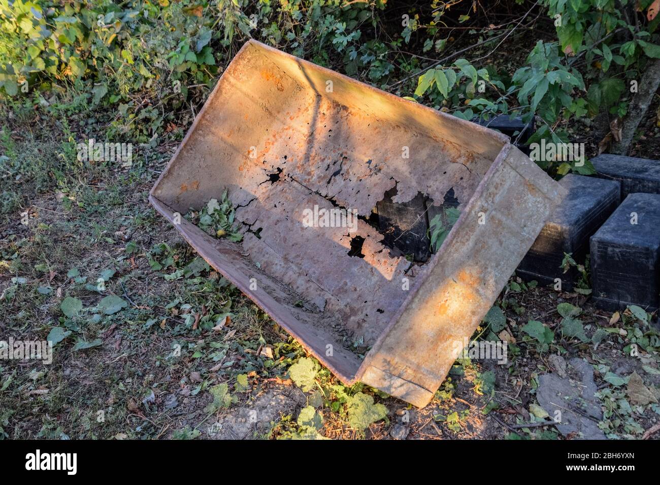 Old rusty holey steel trough. Scrap metal is rusty Stock Photo - Alamy