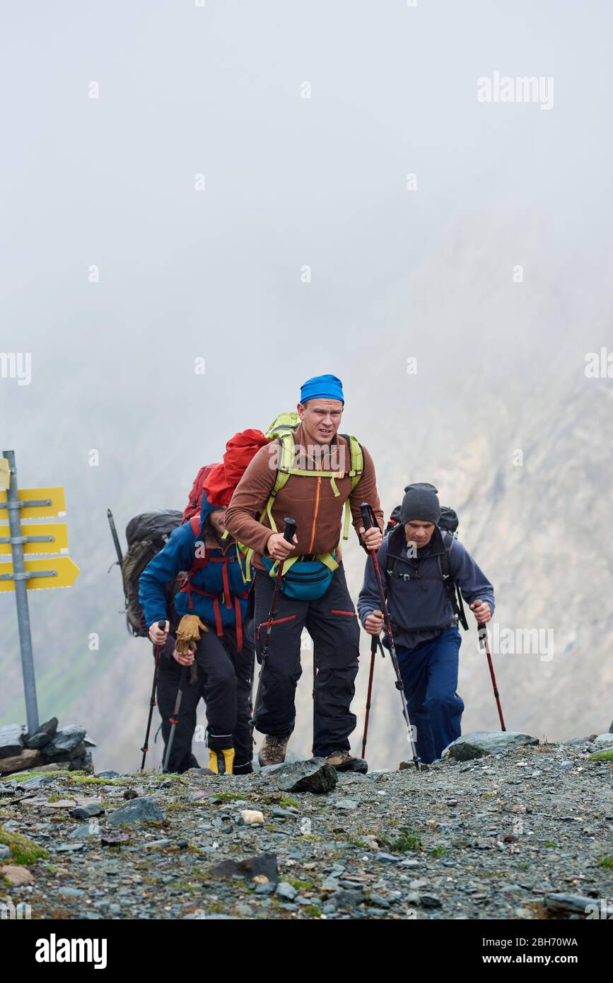 Male hikers reaching mountain top hi-res stock photography and images ...