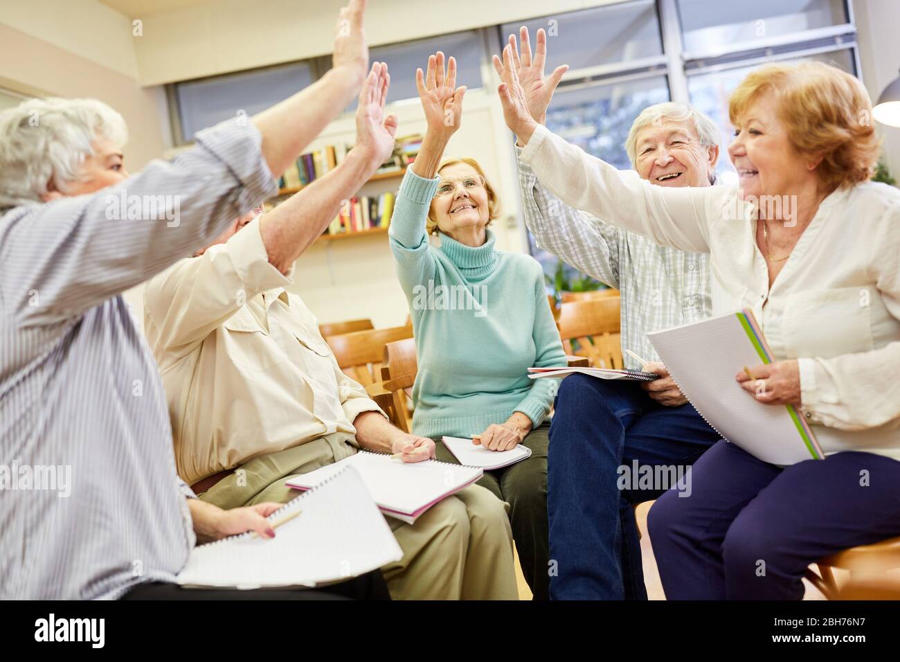 Group of vital seniors does high five exercise for interaction and ...