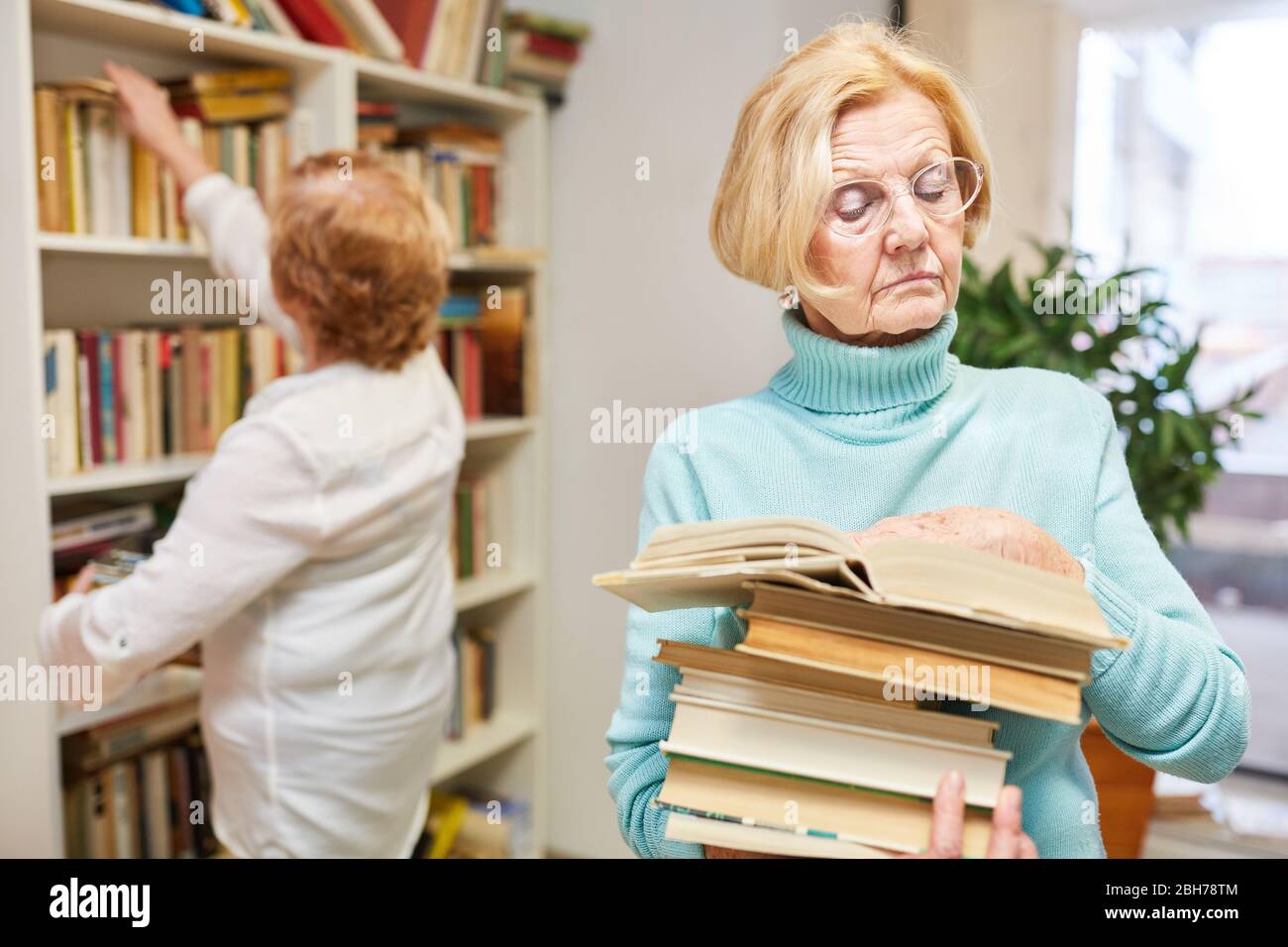 Old woman reads a book in a library hi-res stock photography and images ...