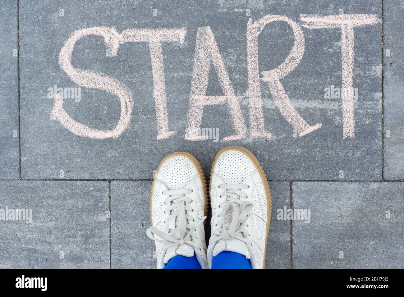 Start concept. Teenager girl standing legs on sidewalk in front of word ...