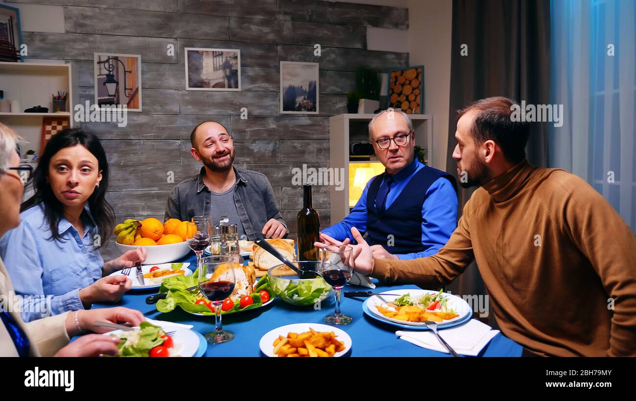 Two sons having a conversation with their father at dinner. Delicious ...