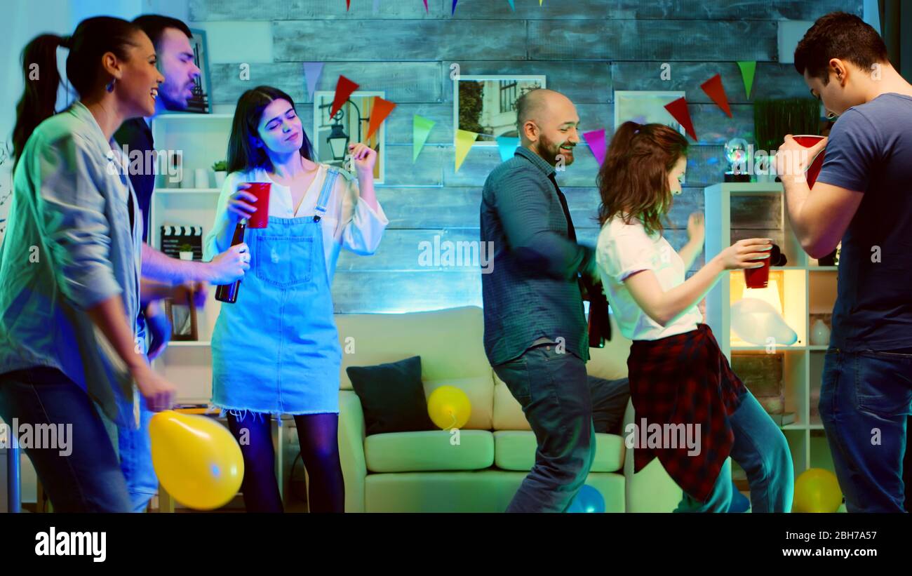 Bald attractive young man smiling while dancing at the party with his ...