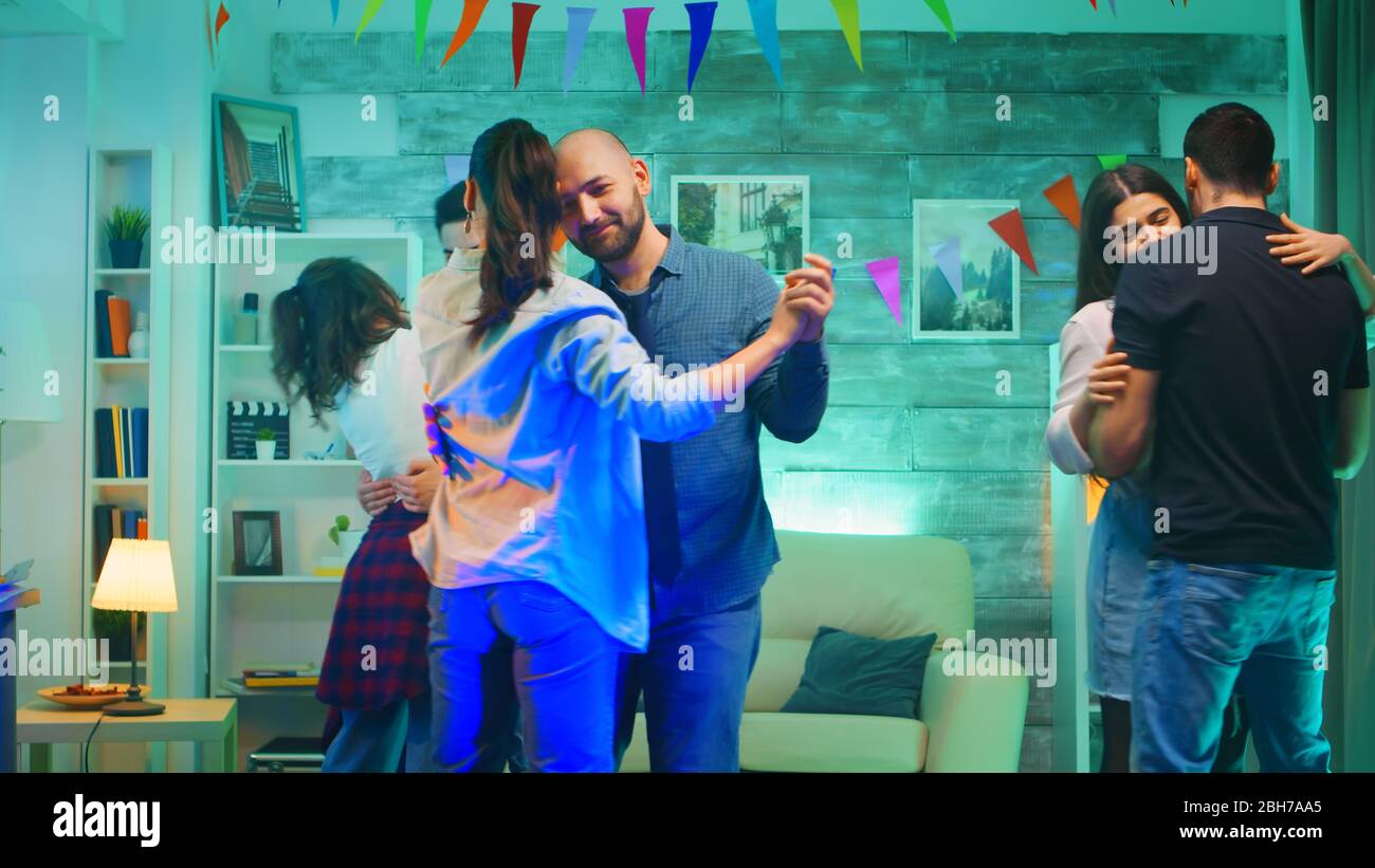 Group of couple dancing on slow music at a party with neon lights ...