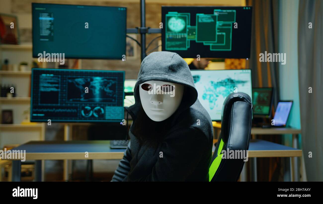 Masked hacker wearing a hoodie to hide his identity. Internet criminal ...
