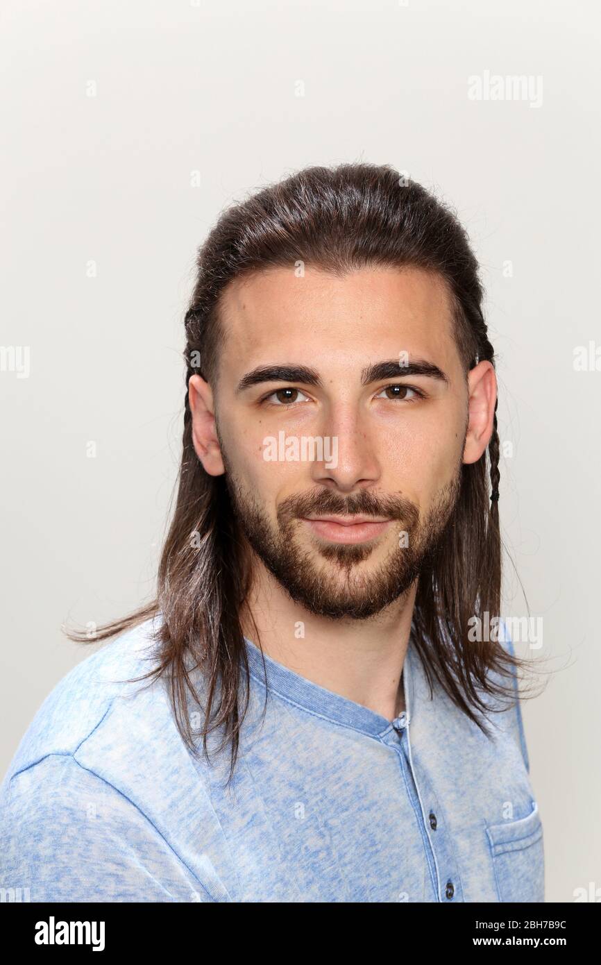 Stylish male model with braids posing in studio on isolated background ...