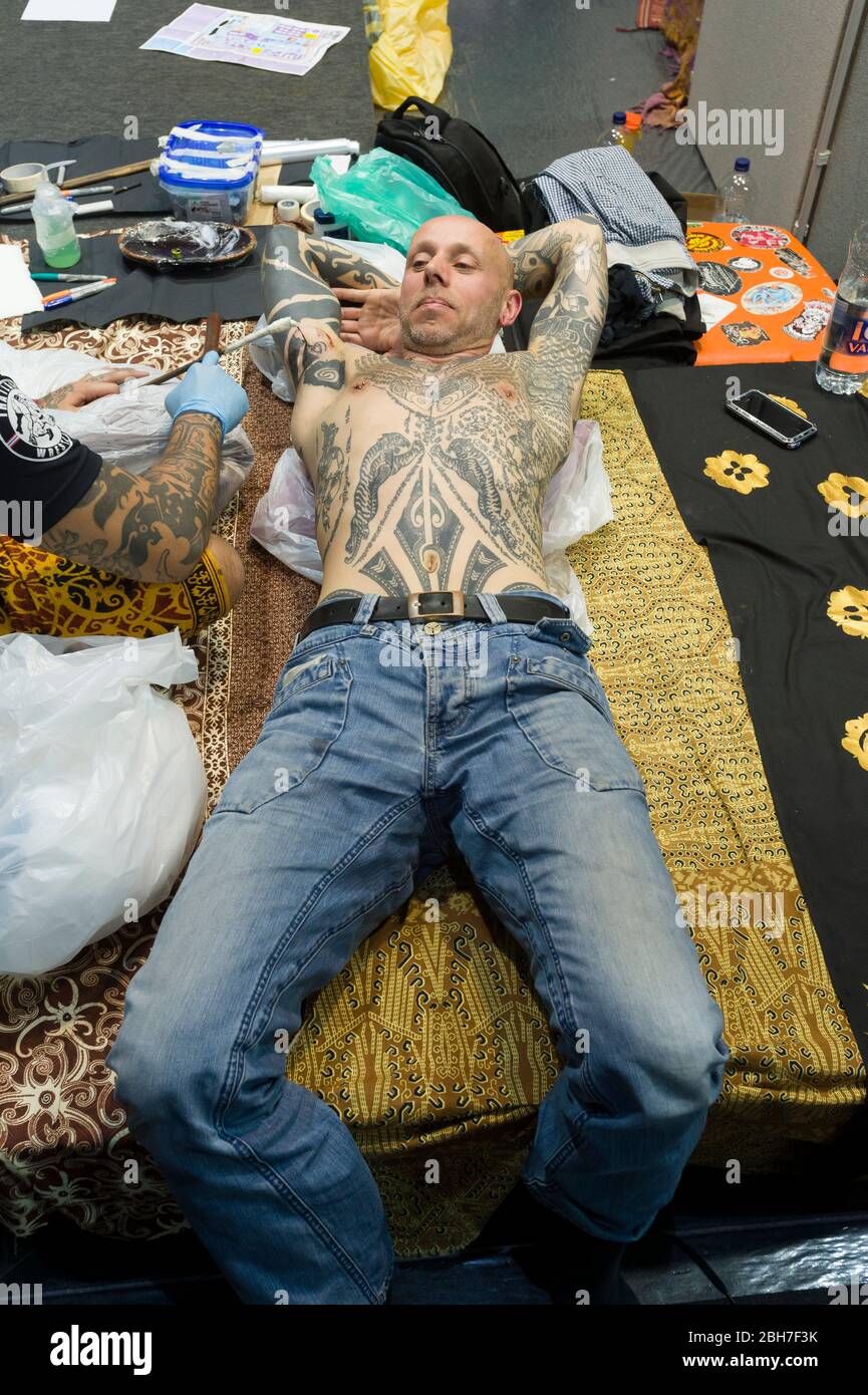 A man getting an arm tattoo by a tattooist using the Rake & Striking ...